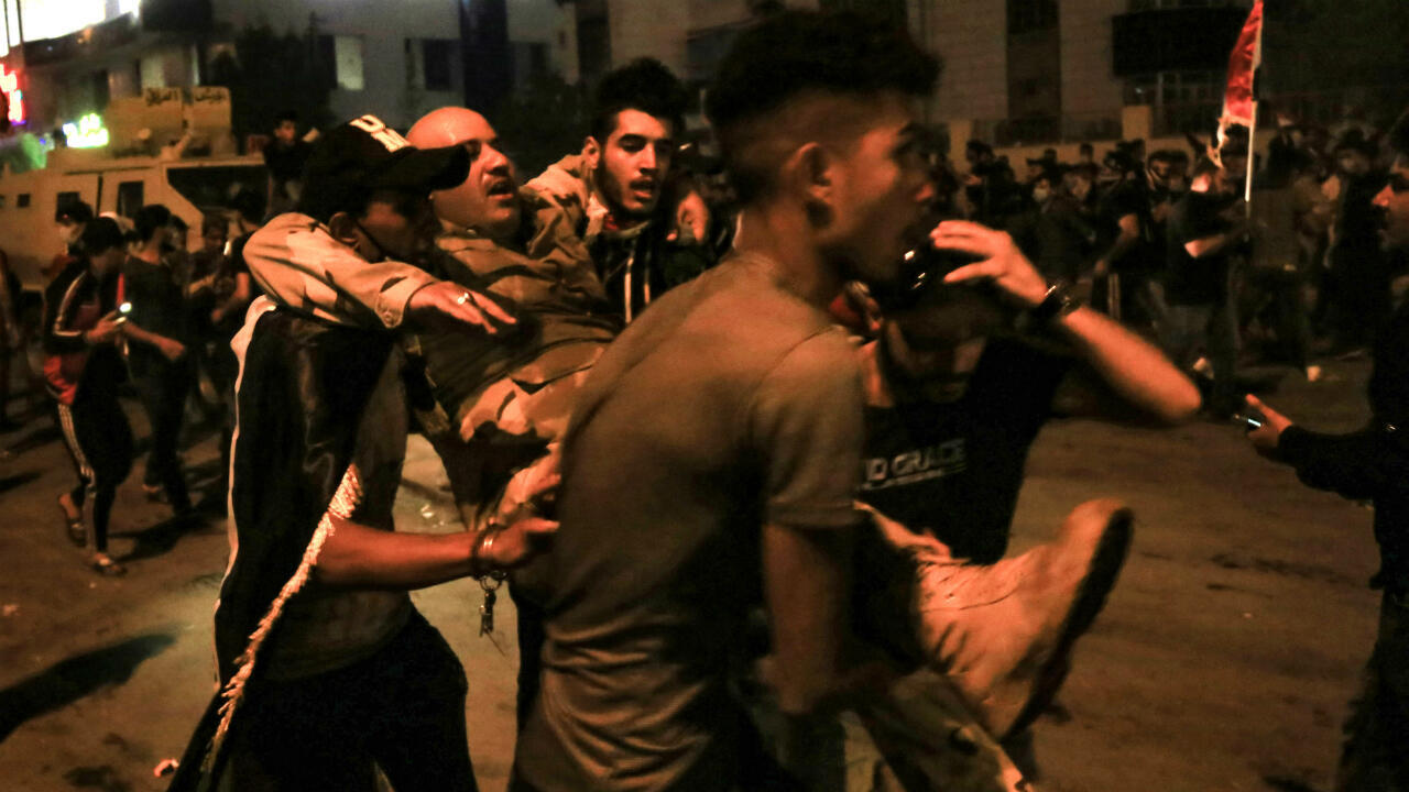 Iraq protesters defy Baghdad curfew as violence rocks Shiite holy city