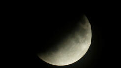 In pictures: Partial lunar eclipse has stargazers seeing red