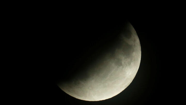 In pictures: Partial lunar eclipse has stargazers seeing red