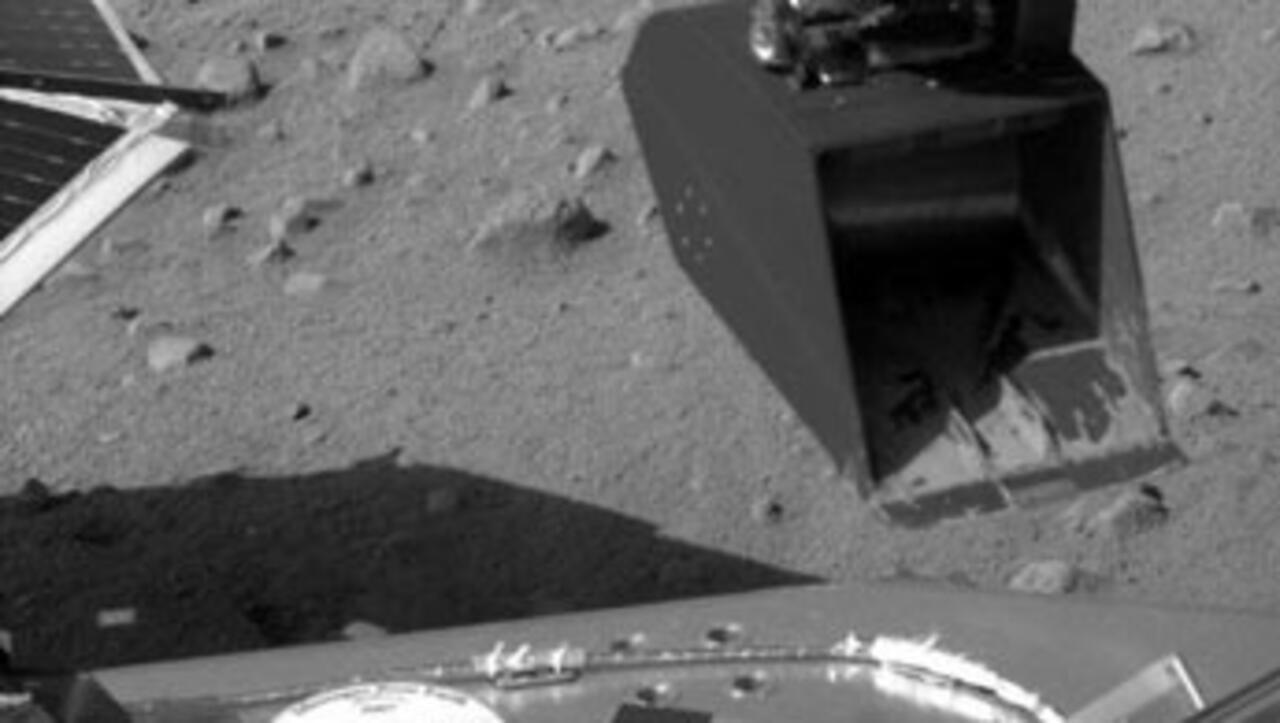 Phoenix probe digs up first Martian soil sample